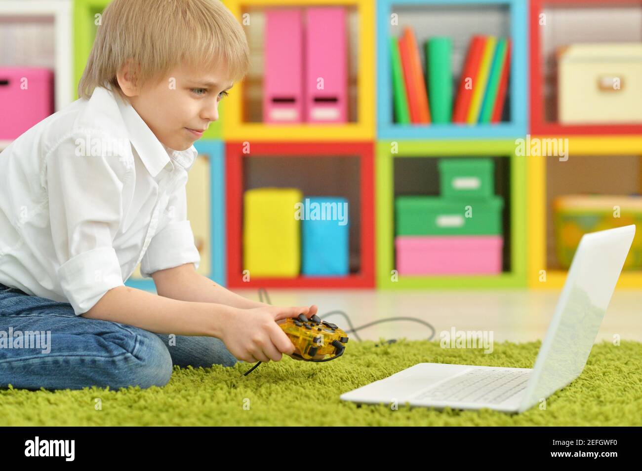 Portrait of boy playing video game on laptop Stock Photo - Alamy