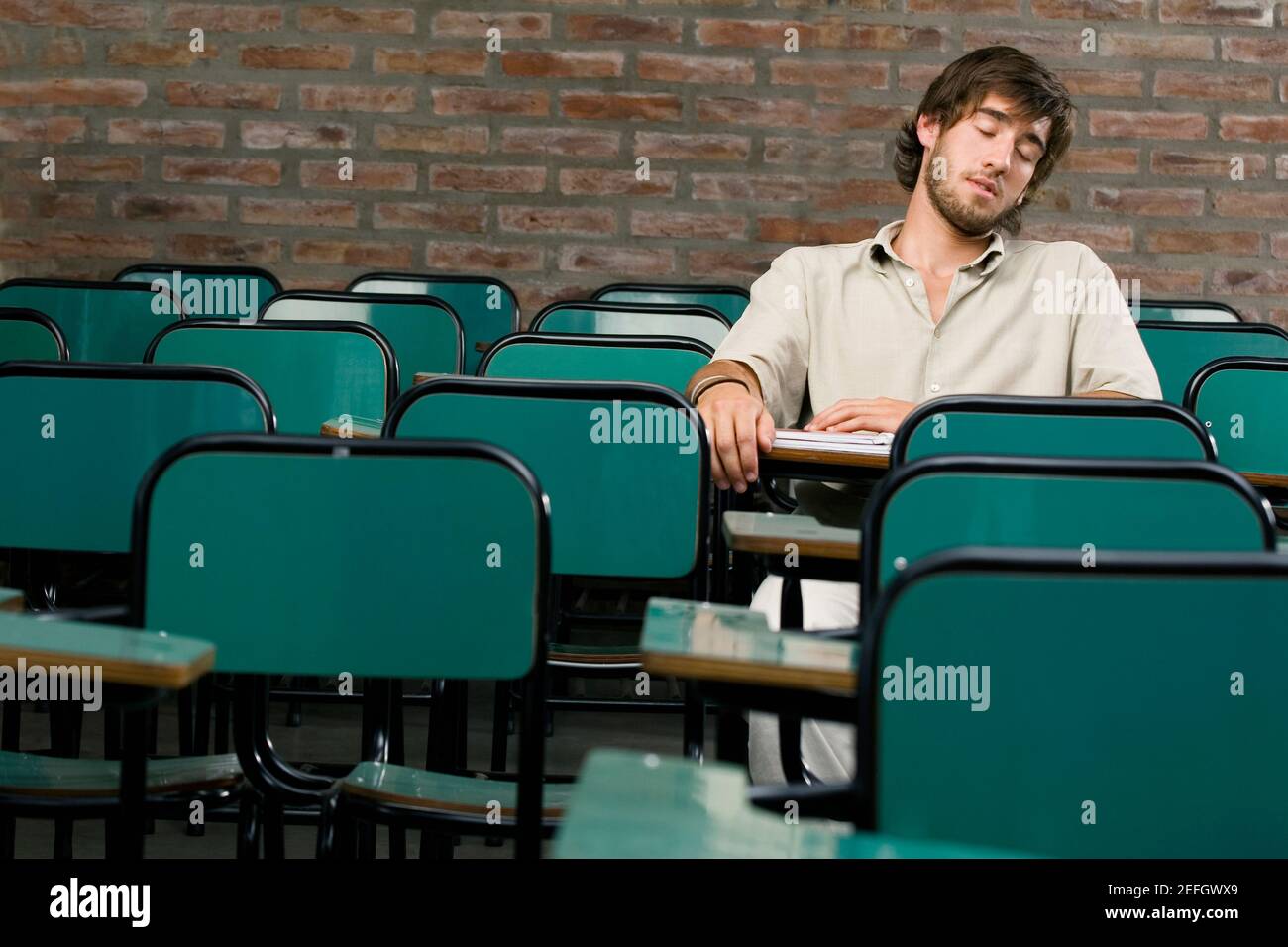 Young man napping in a classroom Stock Photo - Alamy