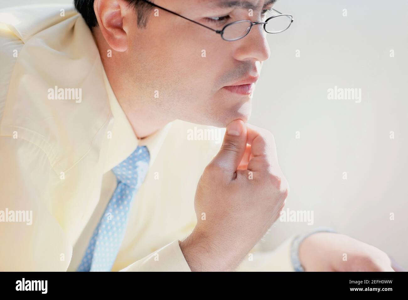 Side profile of a mid adult man with his hand on his chin Stock Photo ...