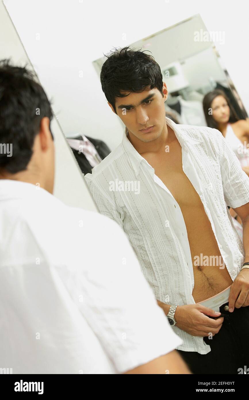 Rear view of a young man putting on pants in a clothing store Stock ...