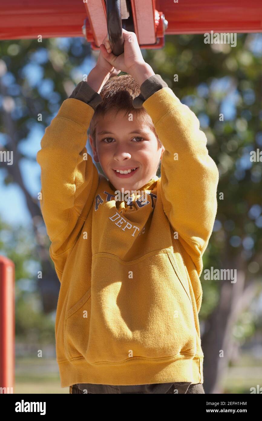 Portrait of a boy hanging on a jungle gym Stock Photo - Alamy