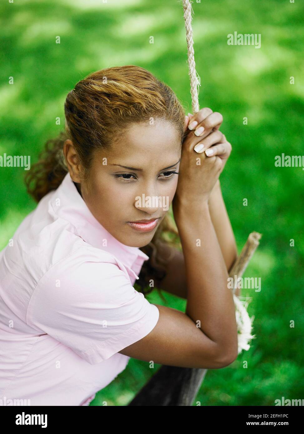 Young woman sitting on a rope swing Stock Photo - Alamy