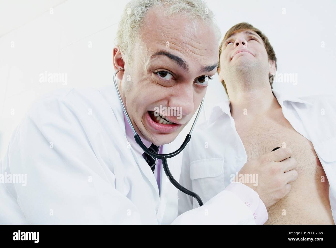Close up of a male doctor examining a patient with a stethoscope and ...