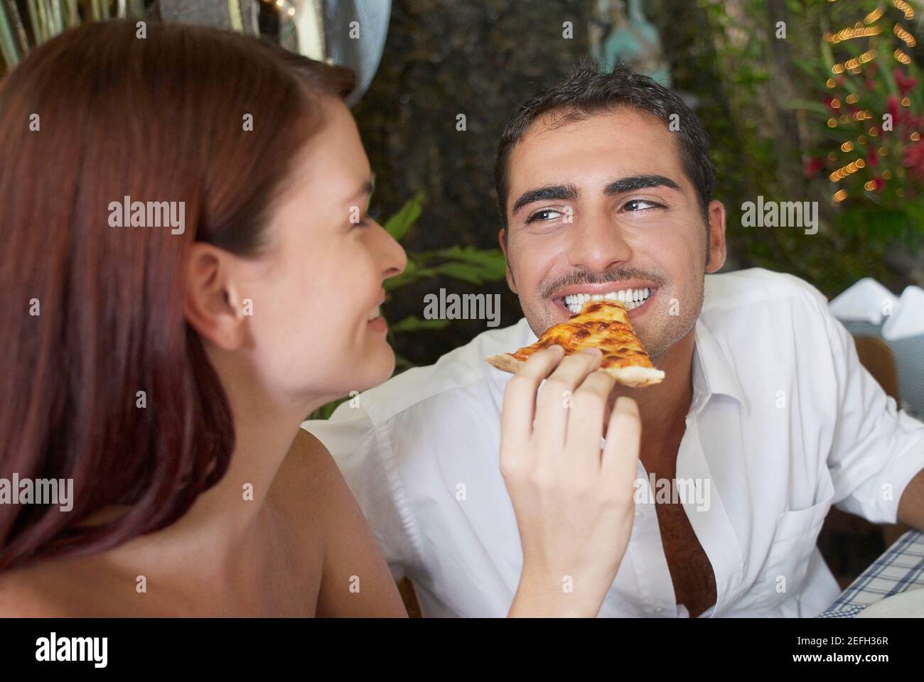 Young woman feeding man junk food hi-res stock photography and images ...