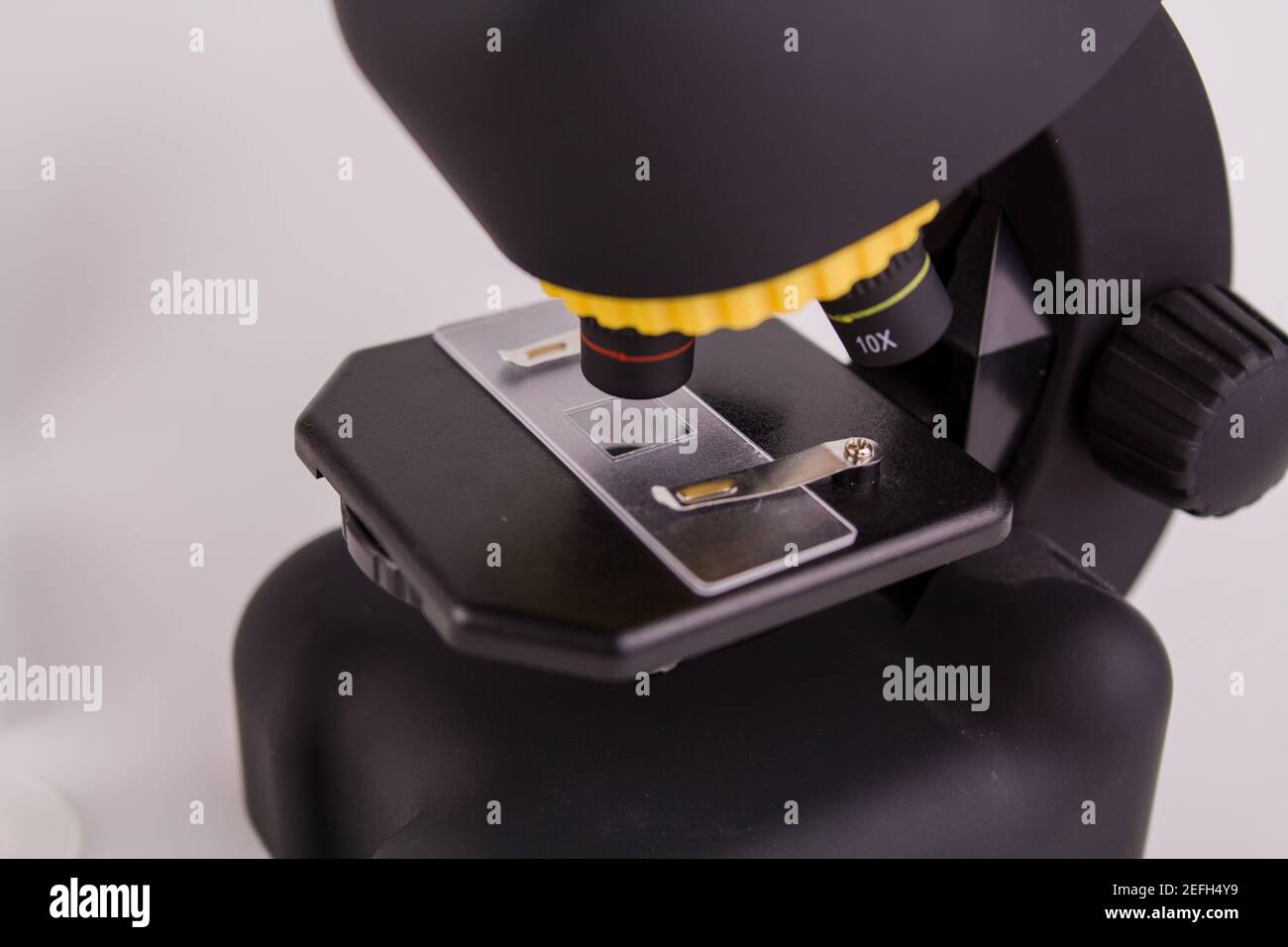 a glass for analysis under a microscope with a sample on a white ...