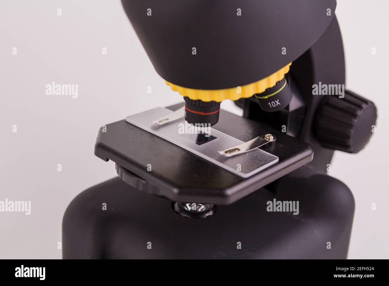 a glass for analysis under a microscope with a sample on a white ...