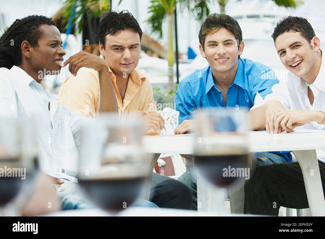Four young men sitting in a restaurant Stock Photo - Alamy
