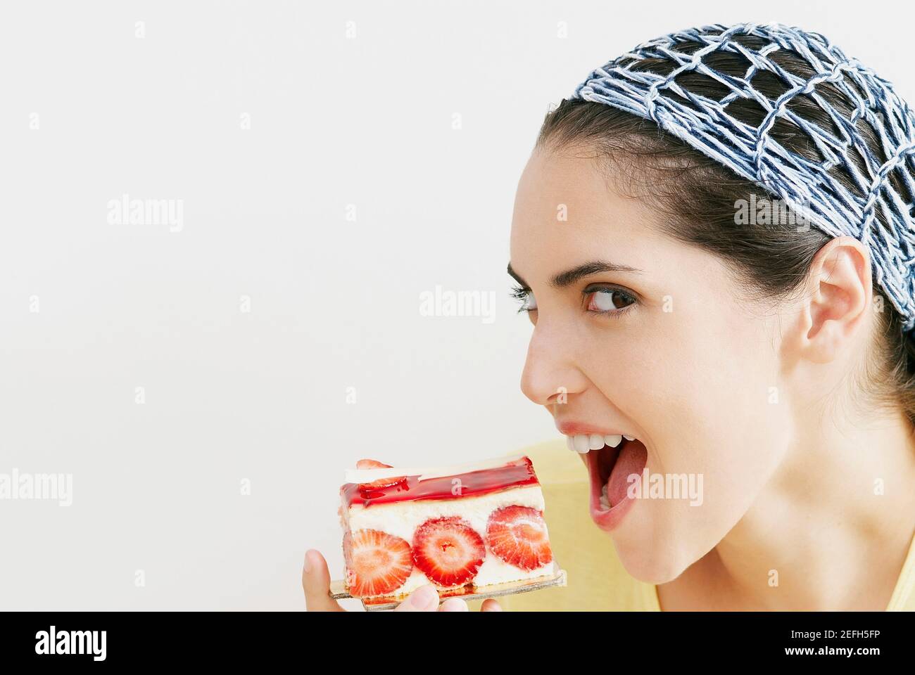 Side profile of a young woman eating a slice of strawberry cake Stock ...
