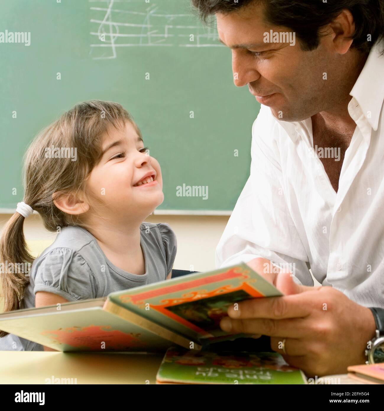 Male teacher teaching his student in a classroom Stock Photo - Alamy