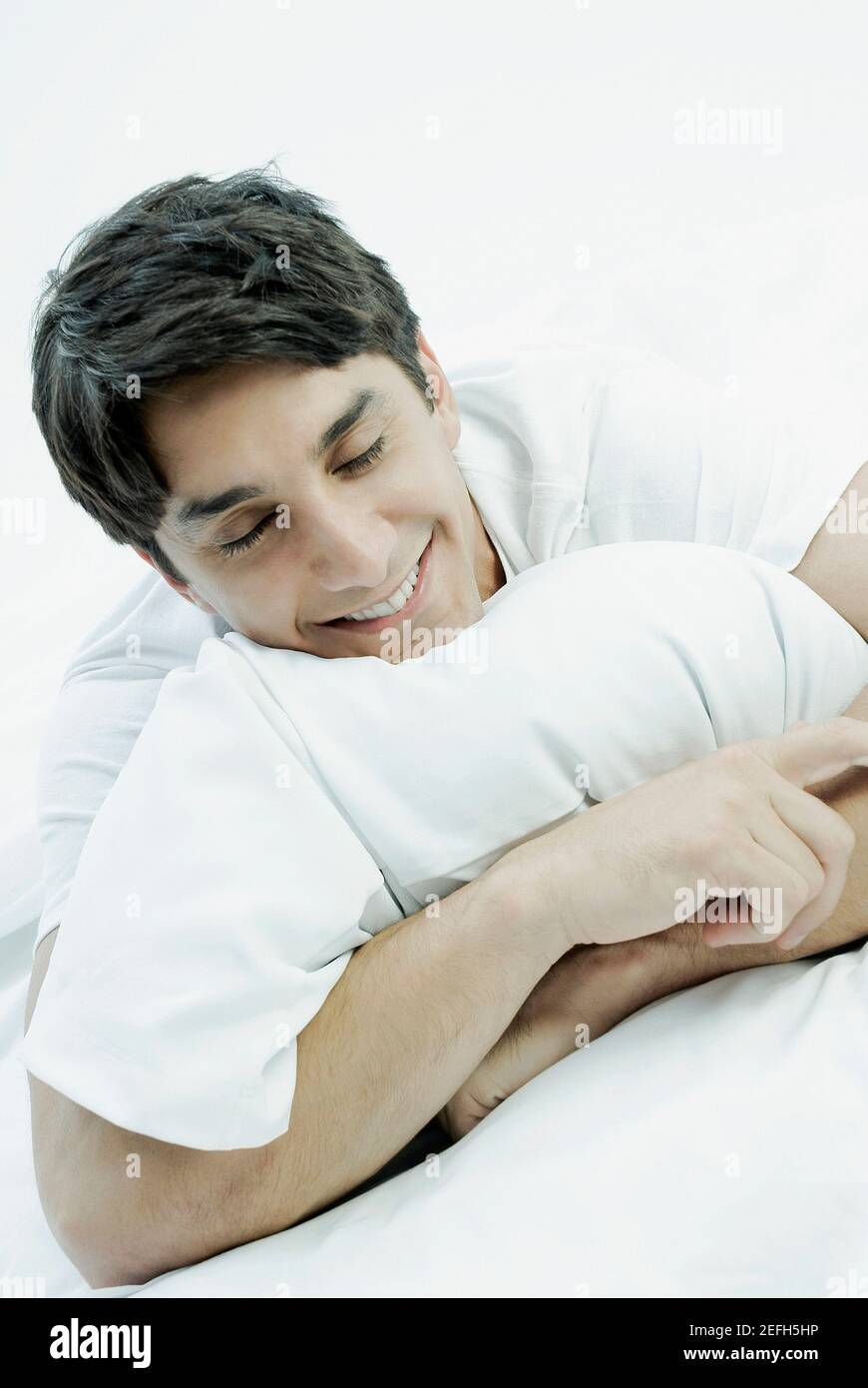 Man hugging pillow on bed hi-res stock photography and images - Alamy