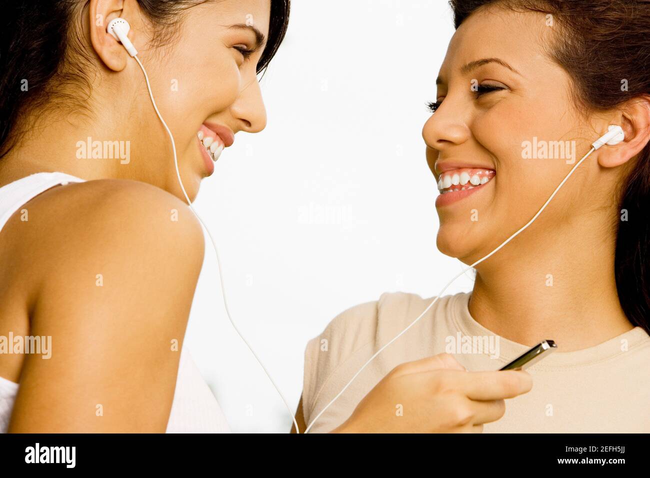 Two teenage girls listening to mp3 player hi-res stock photography and ...