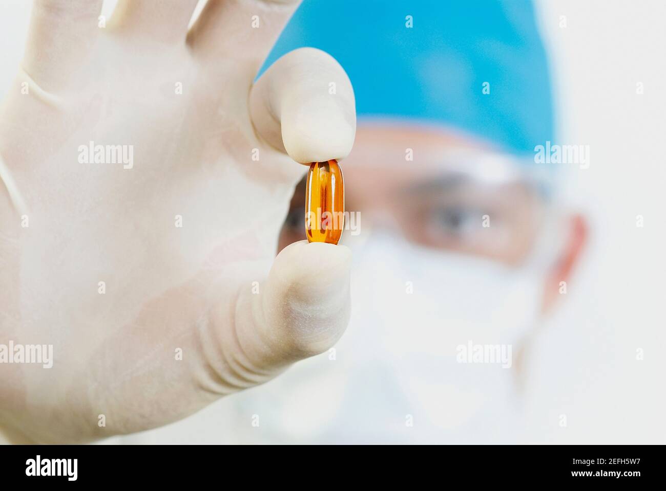 Male doctor showing a capsule Stock Photo - Alamy