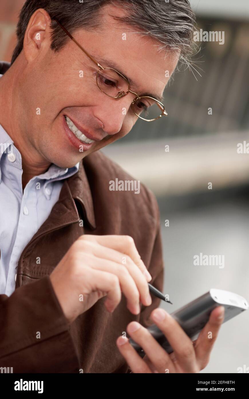 Close-up of a businessman operating a hand held device with a digitized ...