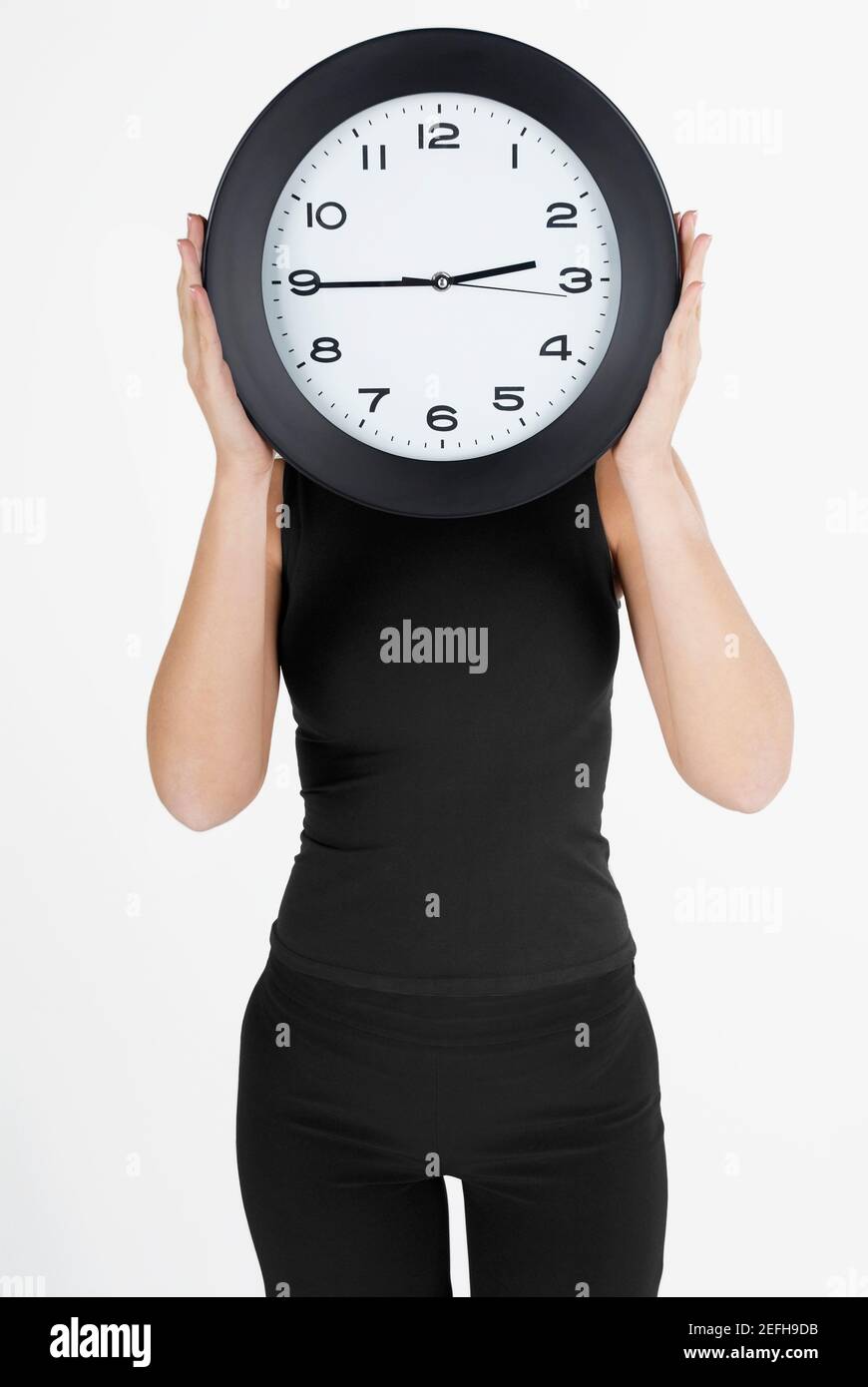 Businesswoman hiding her face with a clock Stock Photo - Alamy