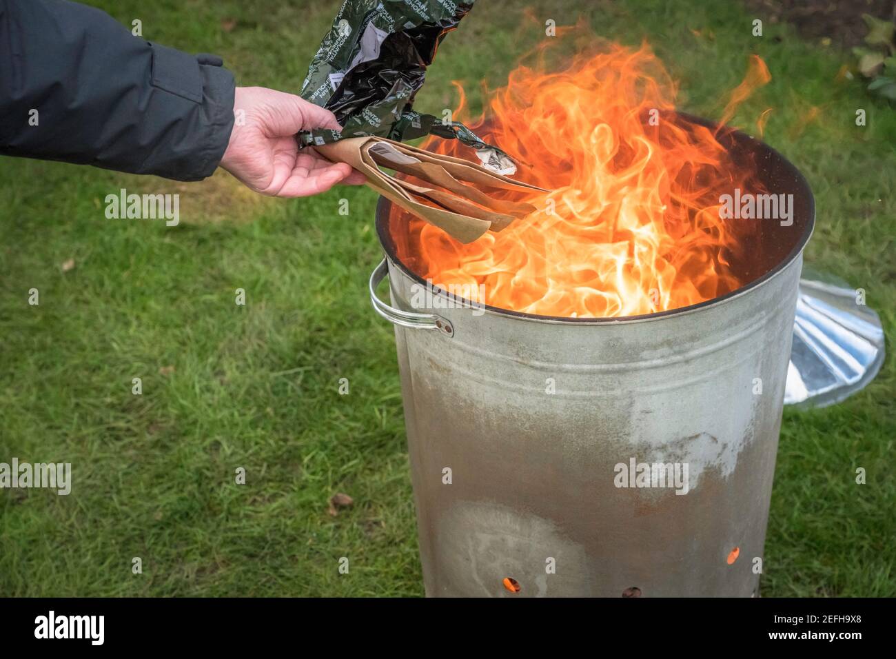 Man throw waste paper in the big incinerator fire at garden Stock Photo ...