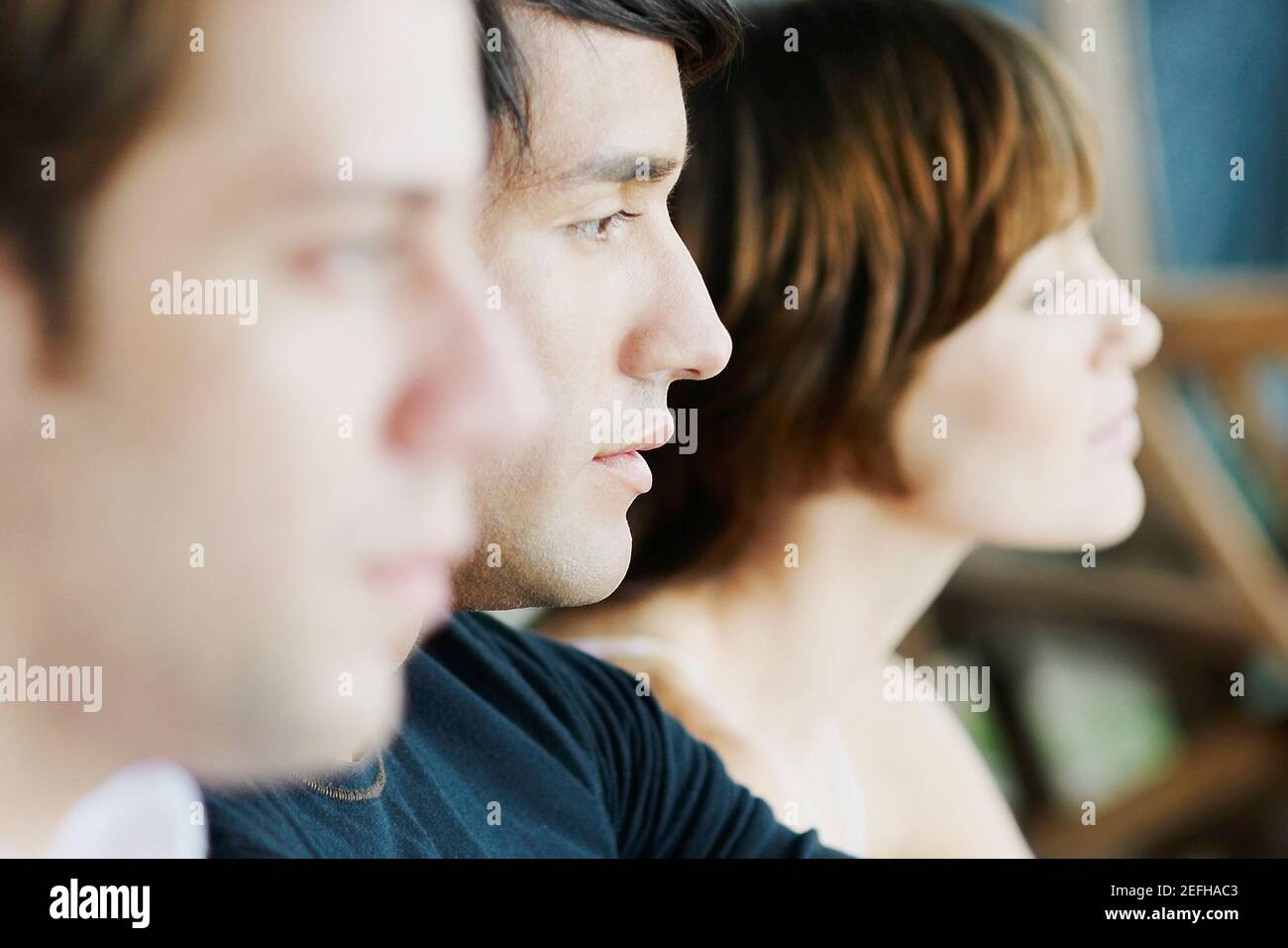 Side profile of two young men and a young woman Stock Photo - Alamy