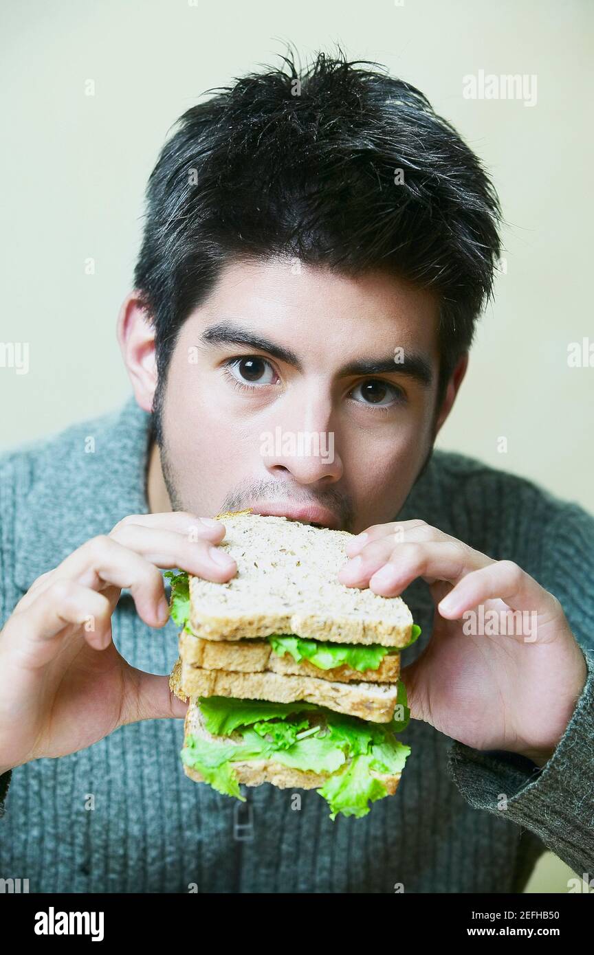 Close up of a young man eating a sandwich Stock Photo - Alamy