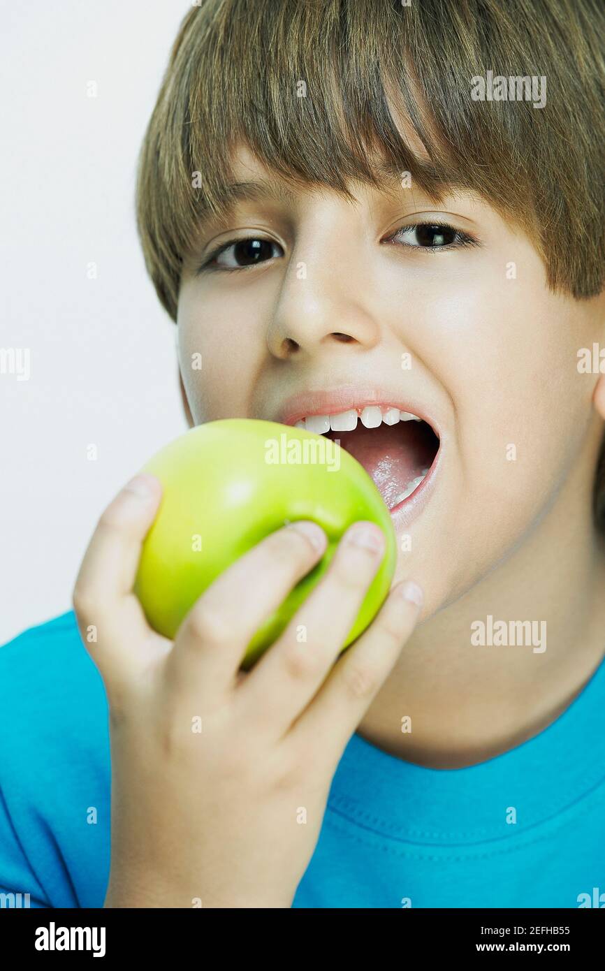 Portrait of a boy eating an apple Stock Photo - Alamy