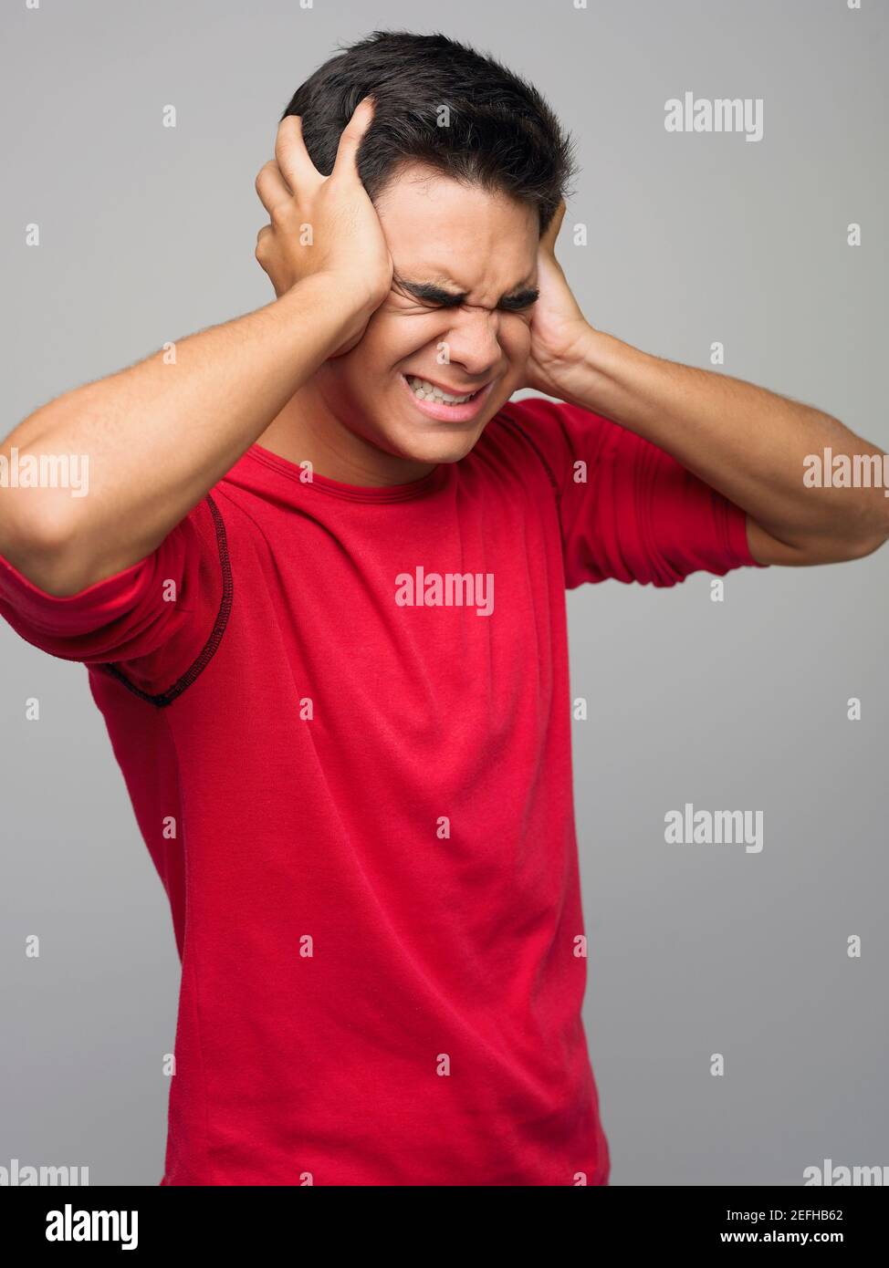 Close up of a young man covering his ears Stock Photo - Alamy