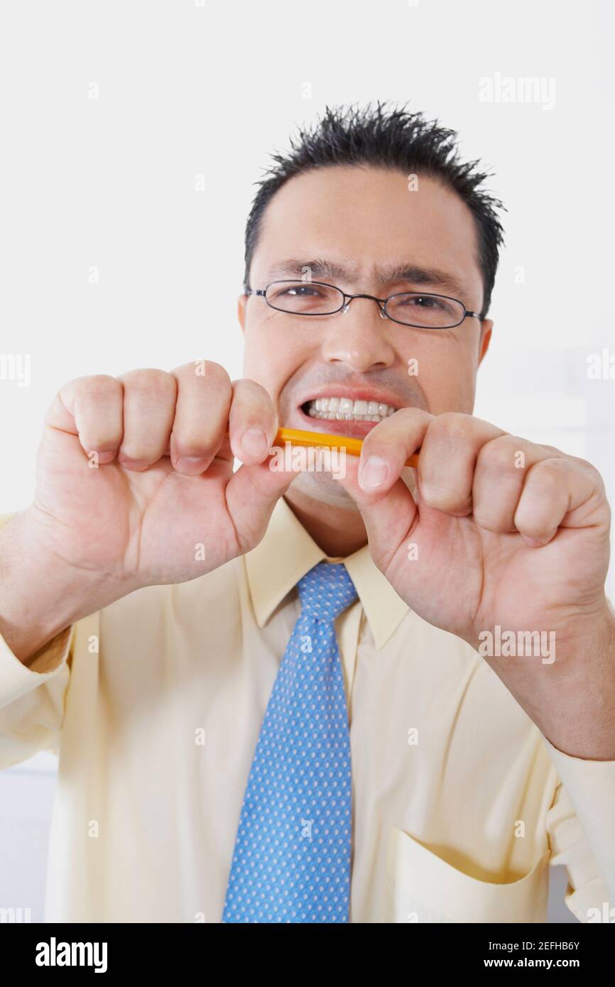 Portrait of a businessman trying to break a pencil Stock Photo - Alamy