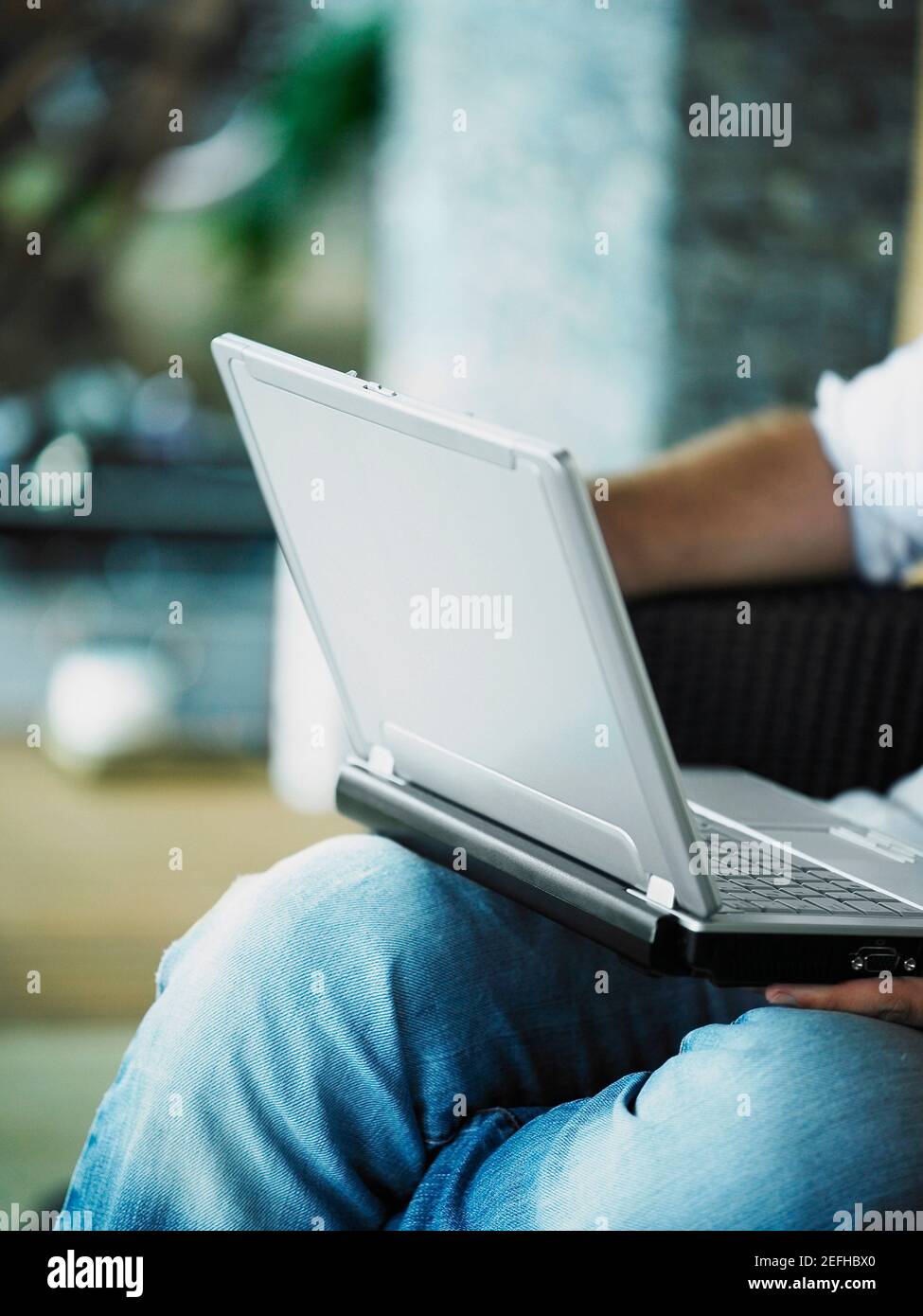 Mid section view of a man sitting with a laptop on his lap Stock Photo ...