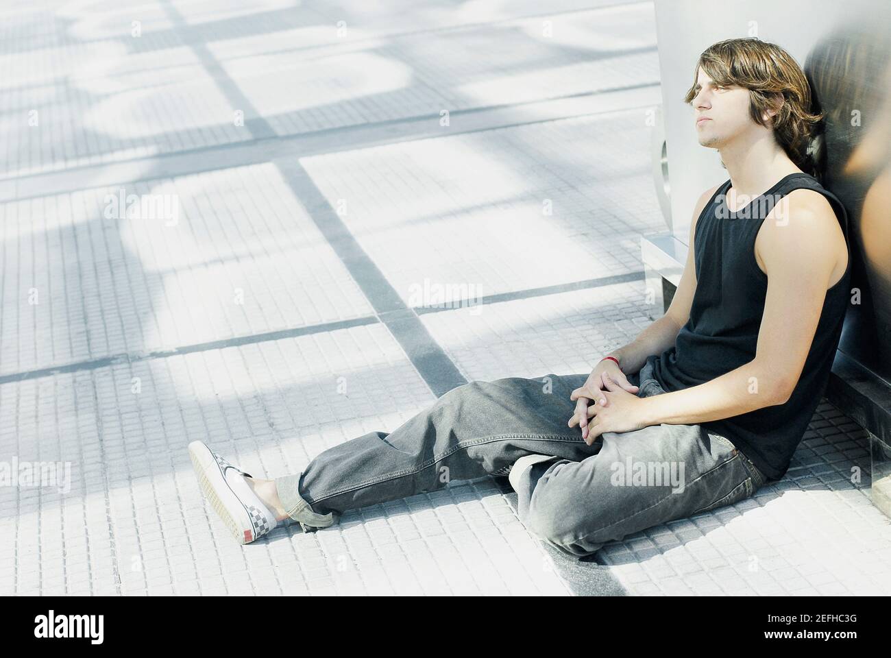 Side profile of a young man sitting on the floor Stock Photo - Alamy