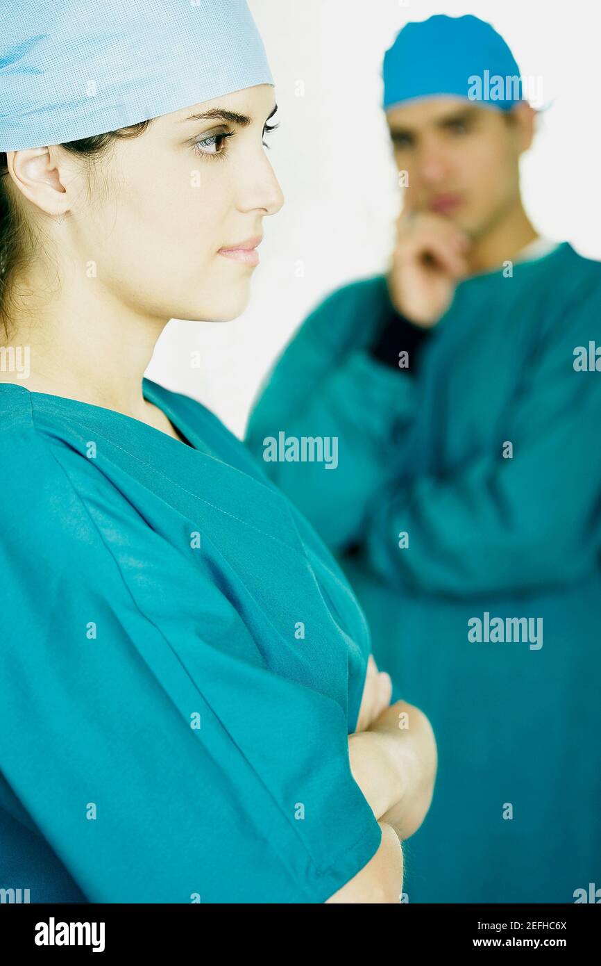Side profile of a female doctor standing with her arms crossed and a ...