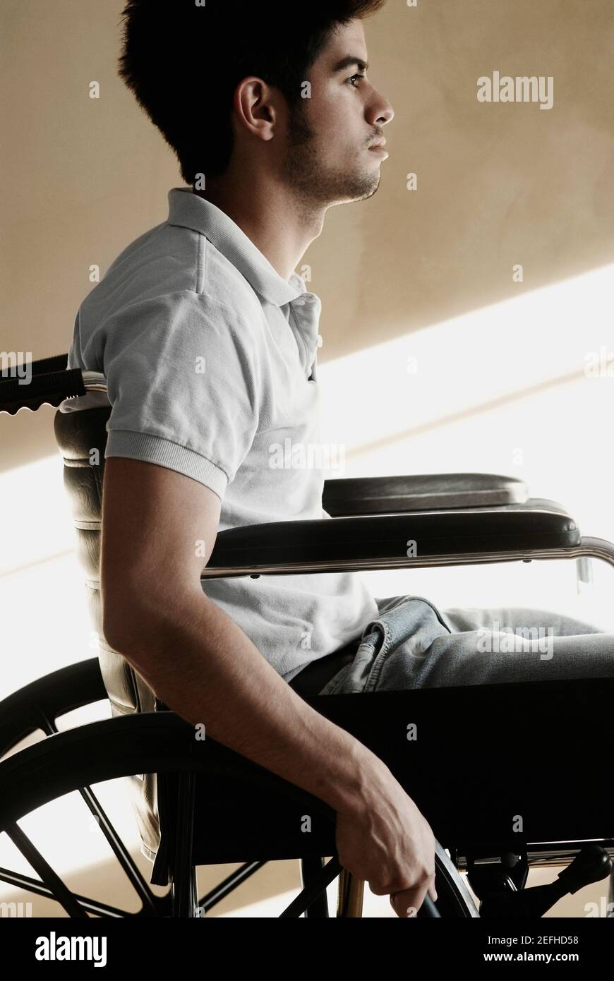 Side profile of a young man sitting in a wheelchair Stock Photo - Alamy