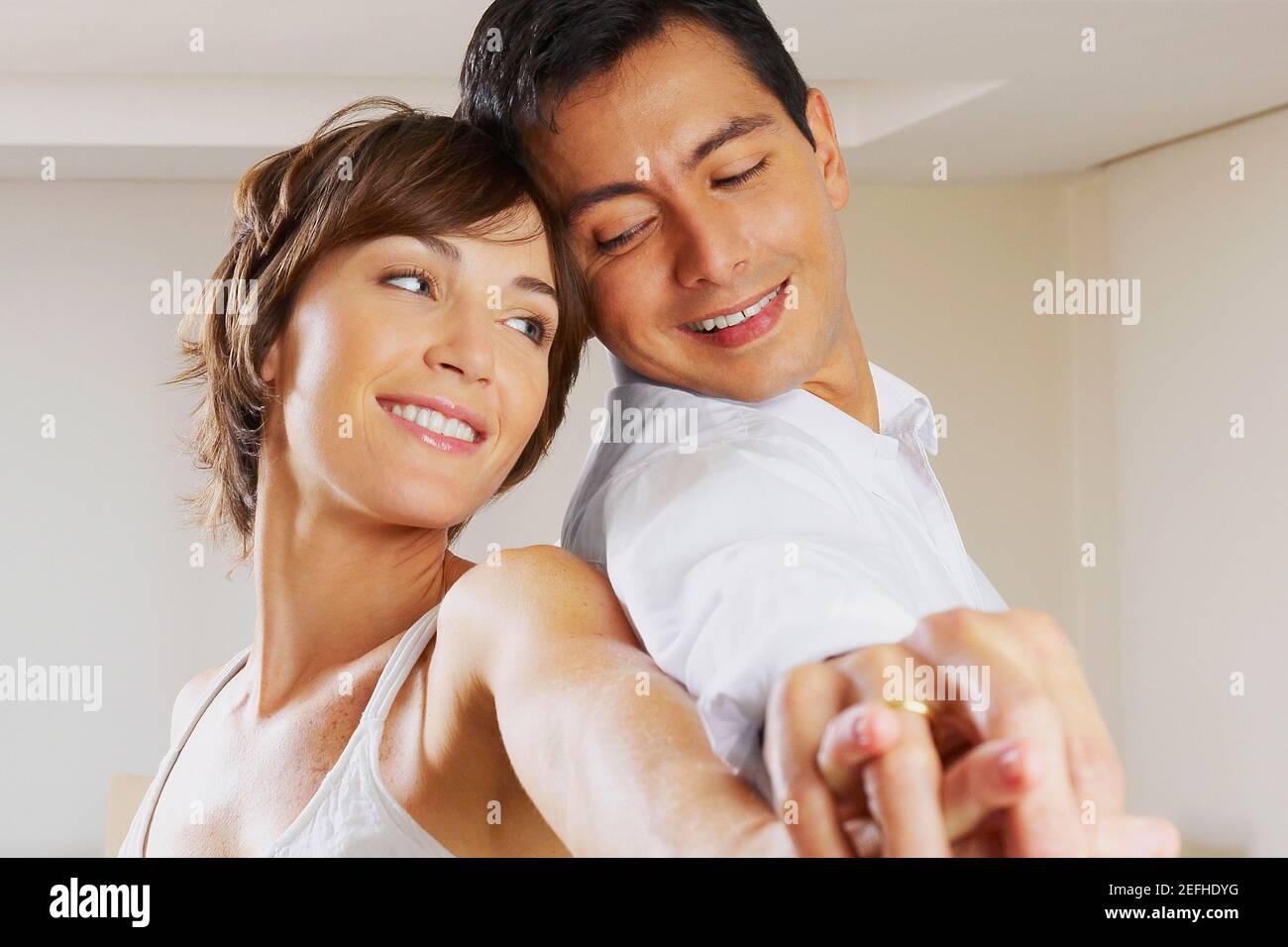 Side profile of a couple back to back and smiling Stock Photo - Alamy