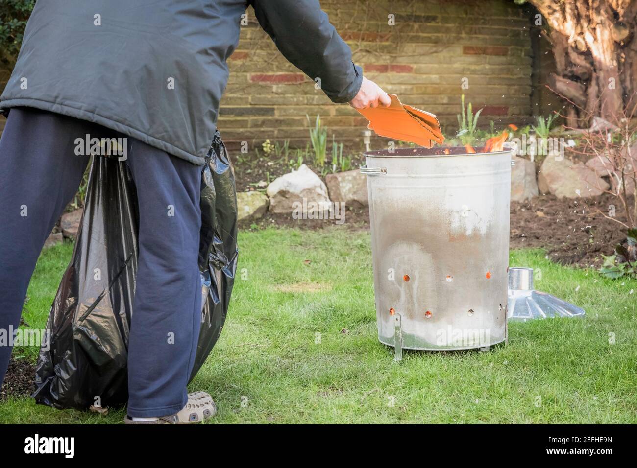 Man throw waste paper in the big incinerator fire at garden Stock Photo ...
