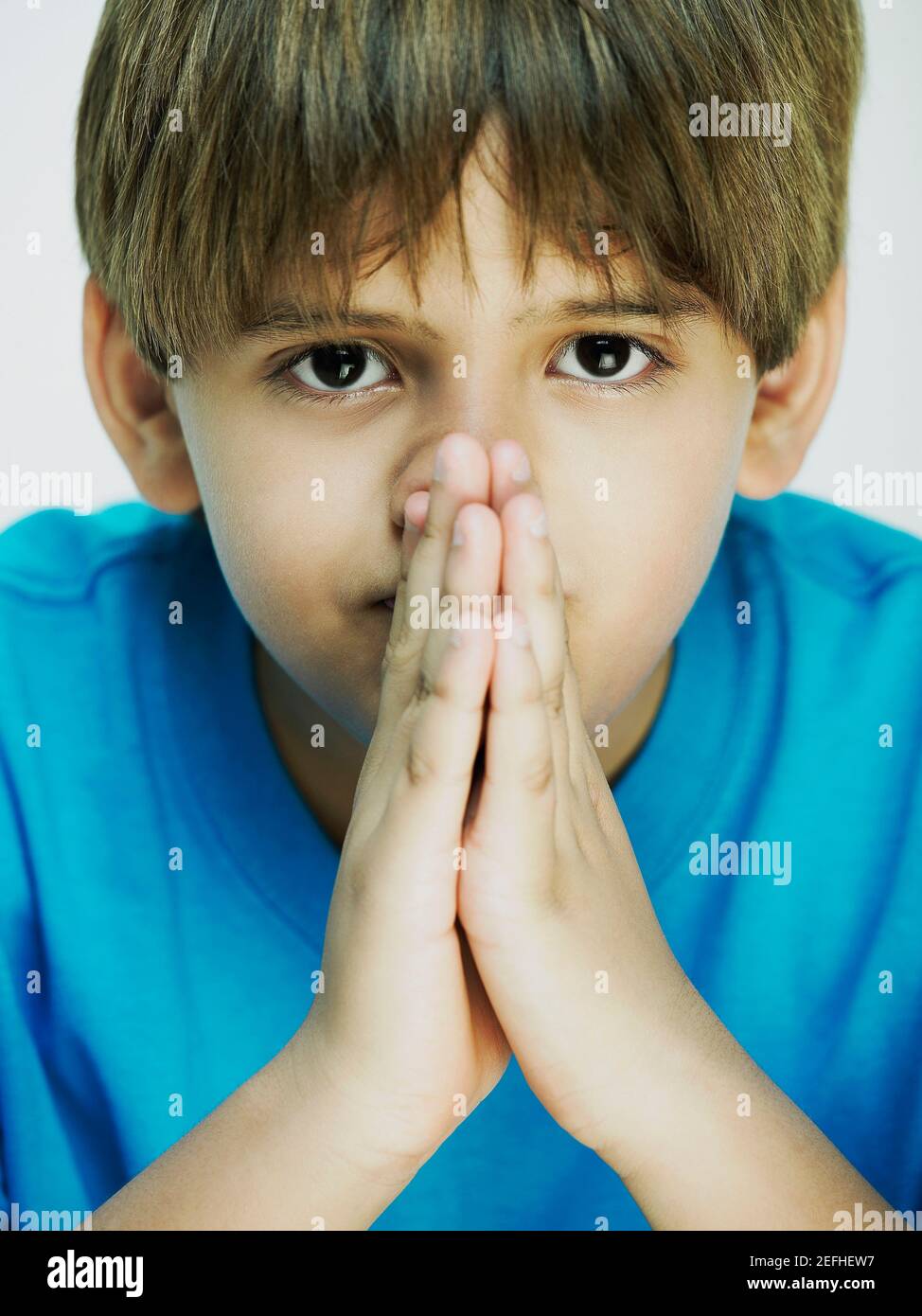 Portrait of a boy in a prayer position Stock Photo - Alamy