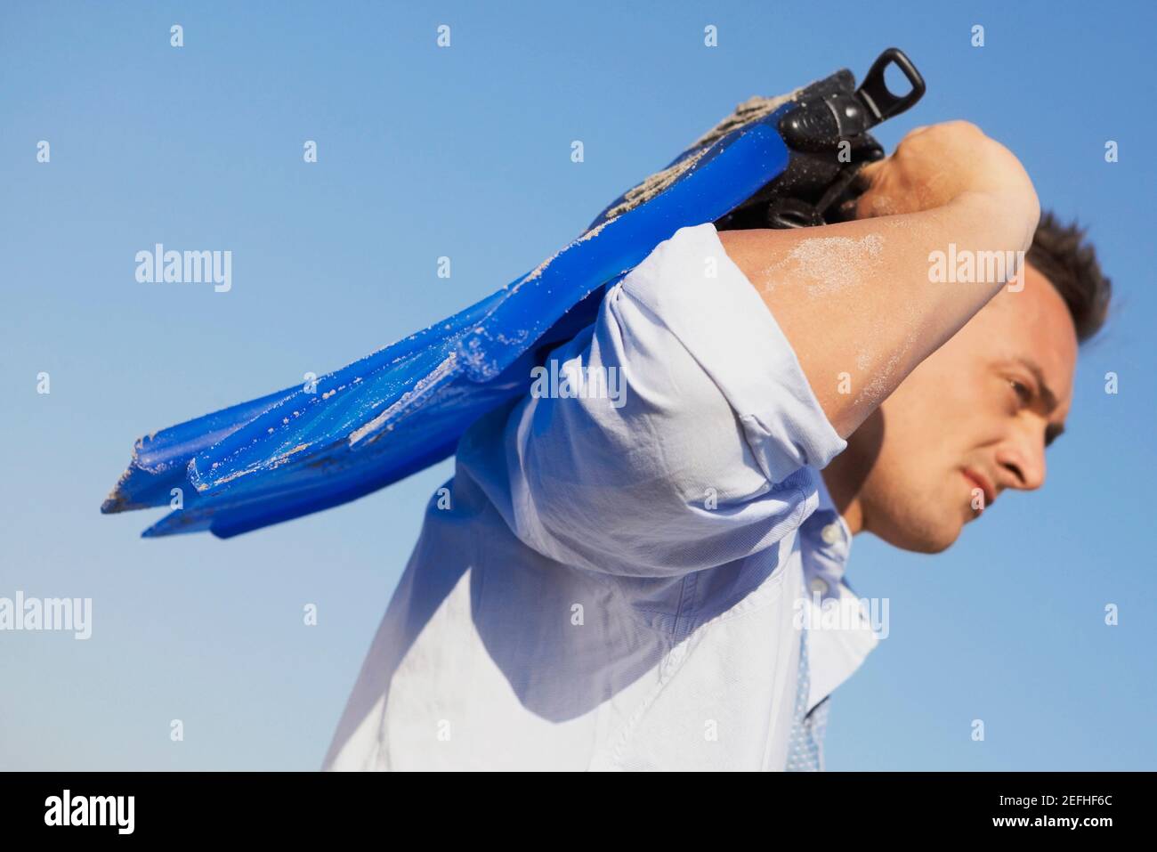 Side profile of a young man holding flippers Stock Photo - Alamy