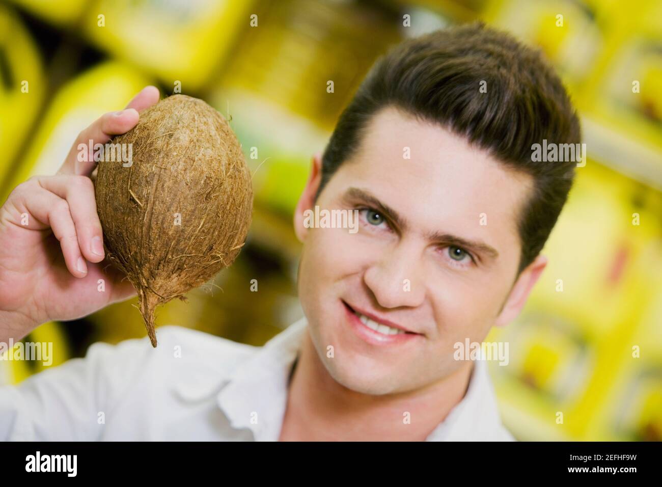 Portrait of a young man holding a coconut Stock Photo - Alamy