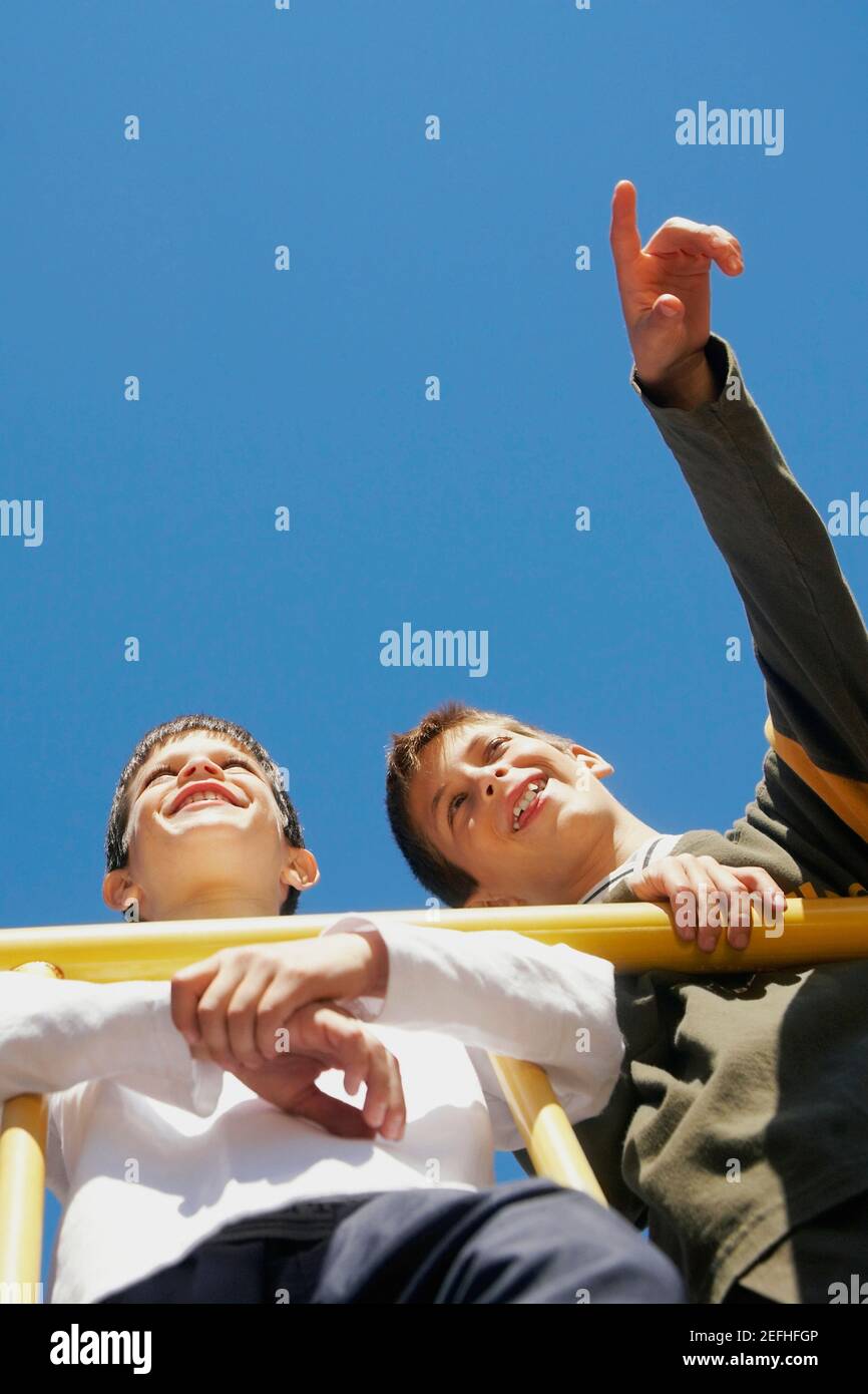 Low angle view of two brothers smiling and standing together Stock ...