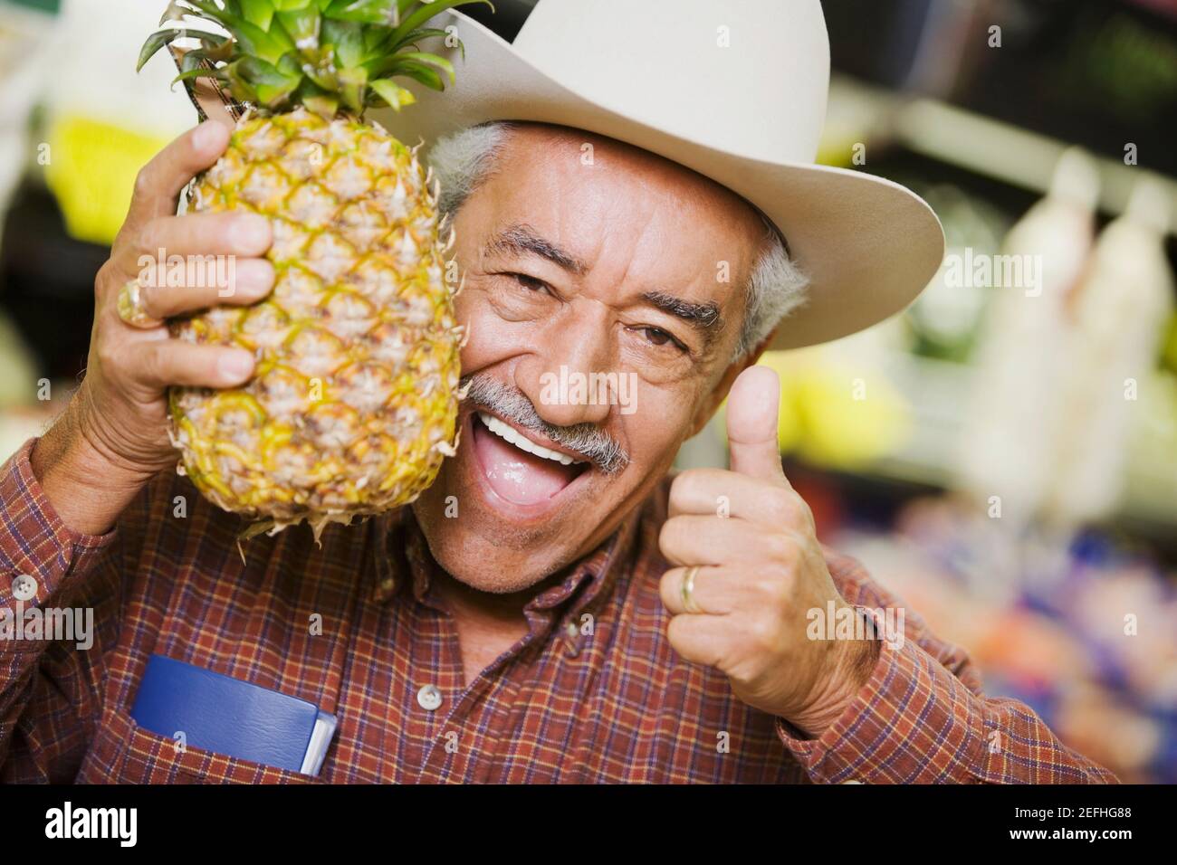 Portrait of a senior man holding a pineapple Stock Photo - Alamy