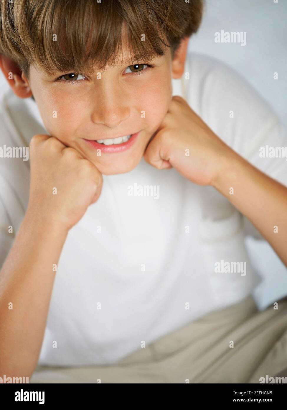 Portrait of a boy smiling with his hand on his chin Stock Photo - Alamy