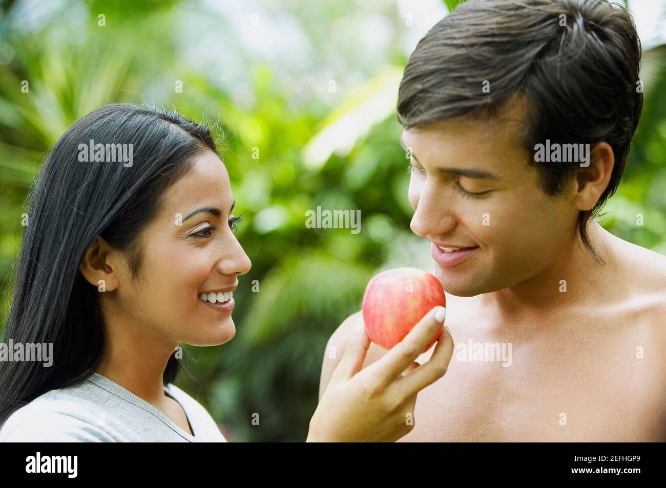 Close up of a young woman giving an apple to a young man Stock Photo ...
