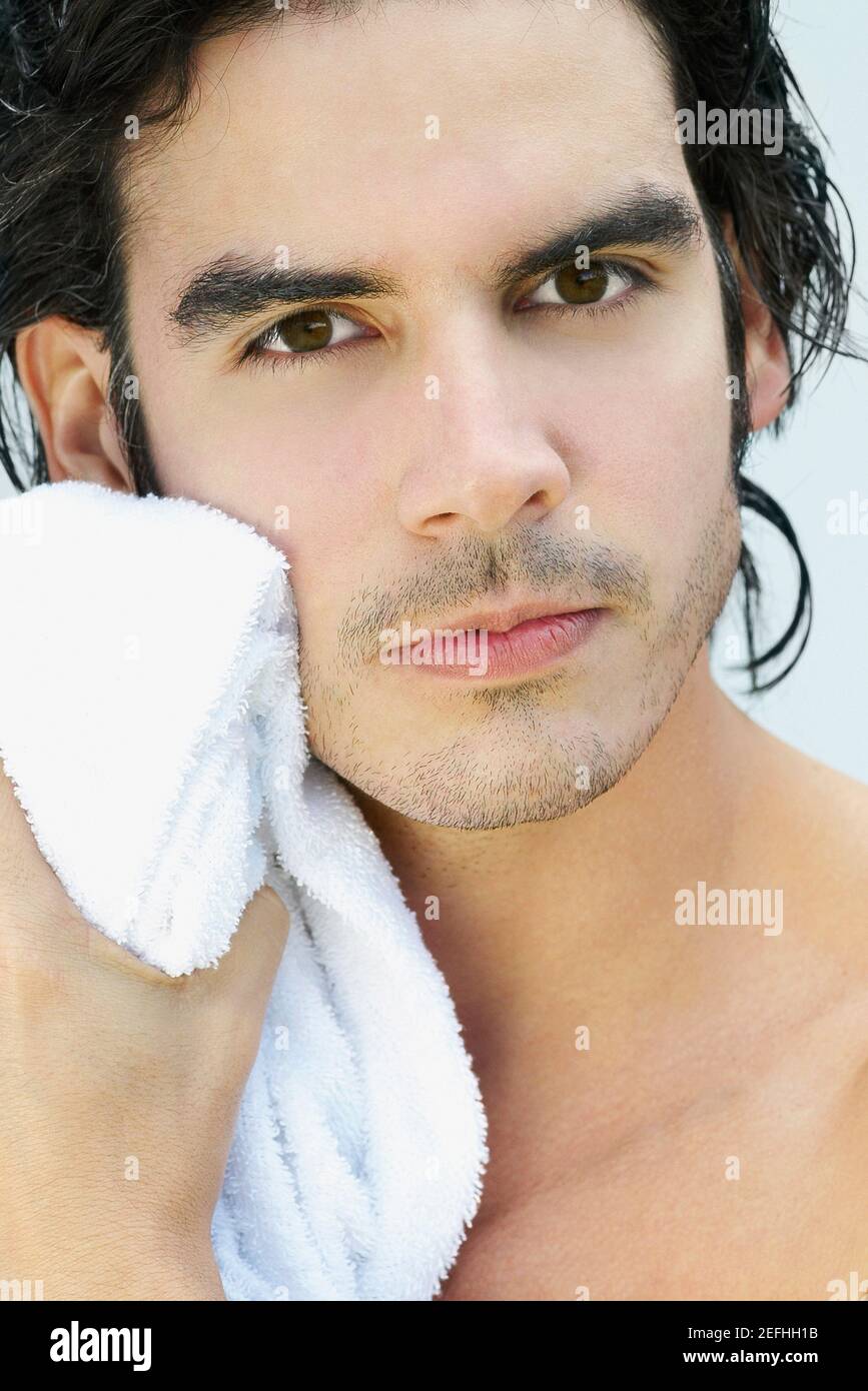 Portrait of a young man wiping his face with a towel Stock Photo - Alamy