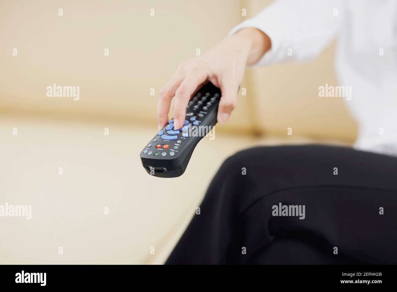 Mid section view of a person holding a remote control Stock Photo - Alamy