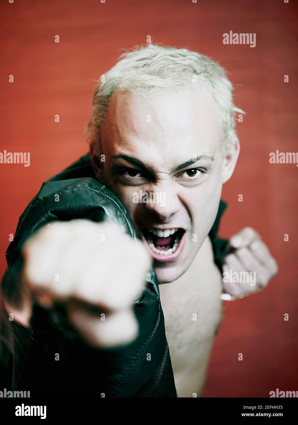 Portrait of a young man punching Stock Photo - Alamy