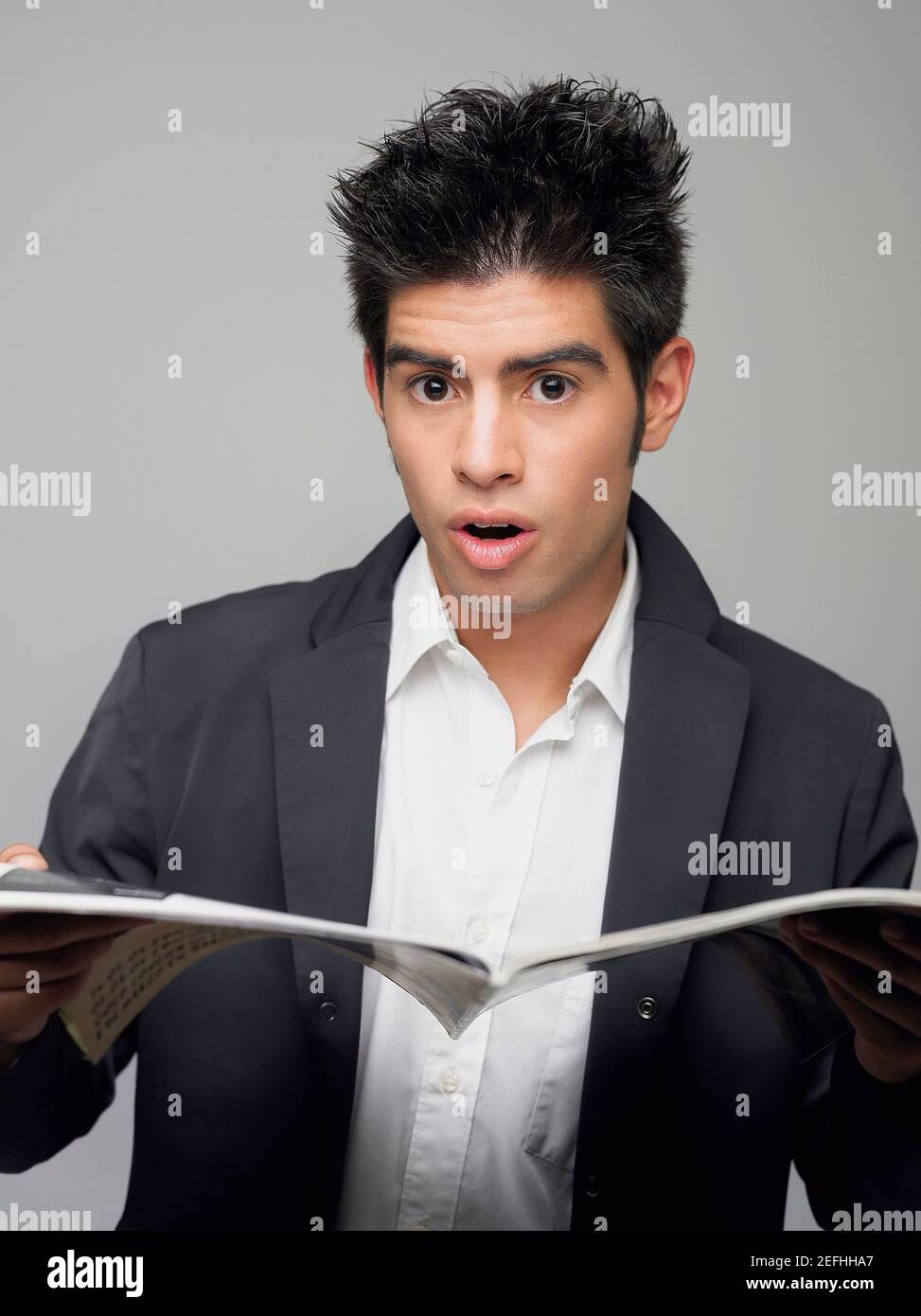 Portrait of a young man holding a magazine Stock Photo - Alamy