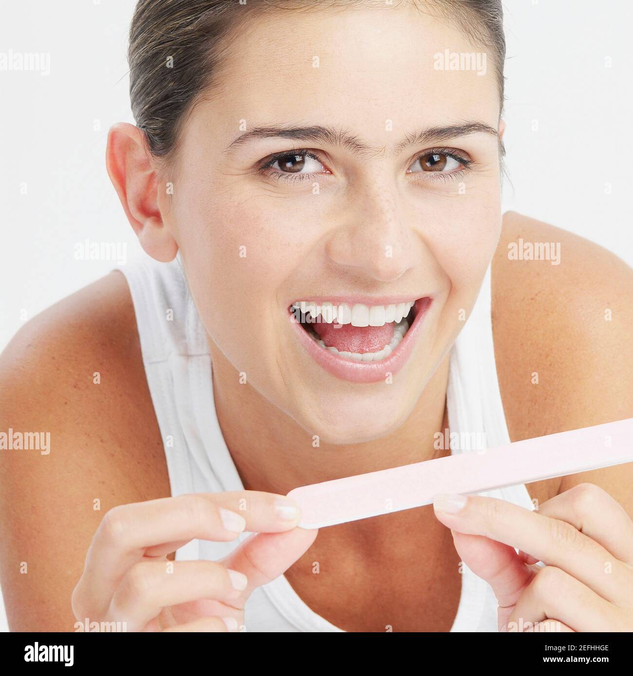 Portrait of a young woman filing her nails and smiling Stock Photo - Alamy