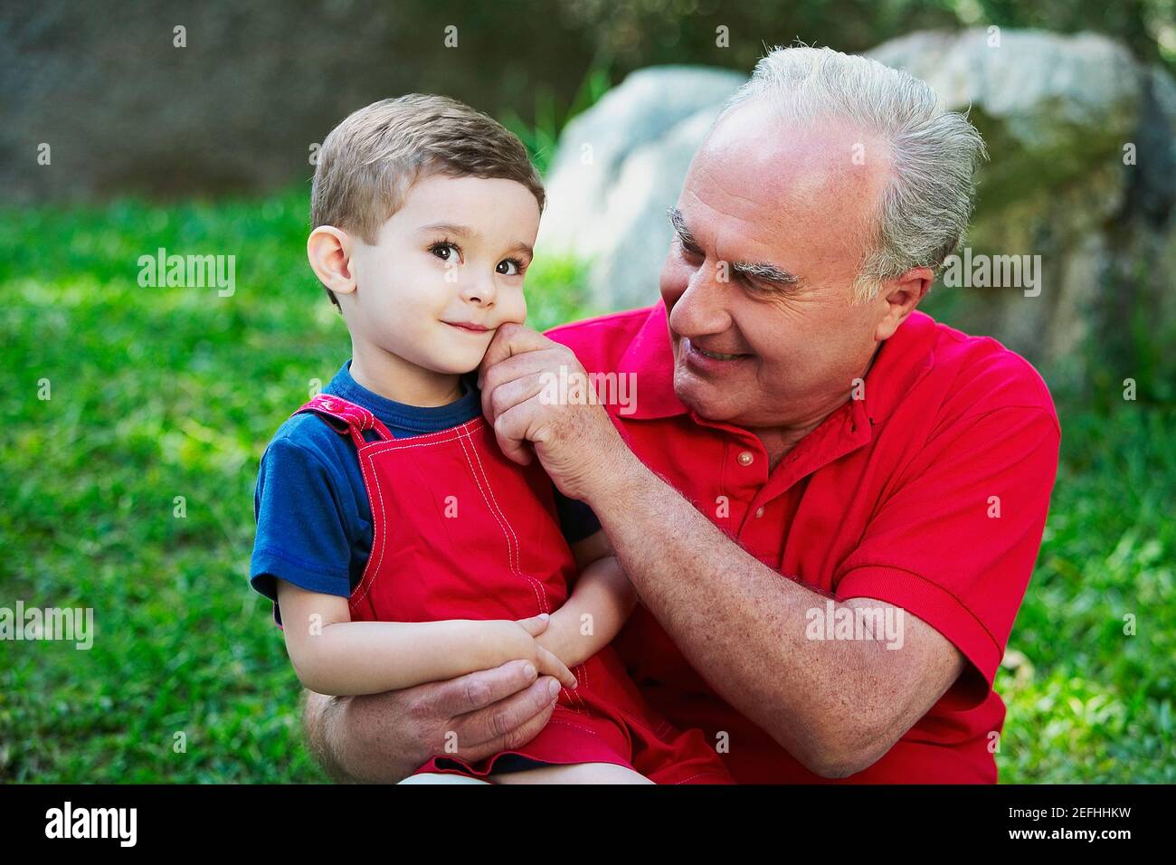 Close up of a senior man pinching his grandsonŽs cheek Stock Photo - Alamy