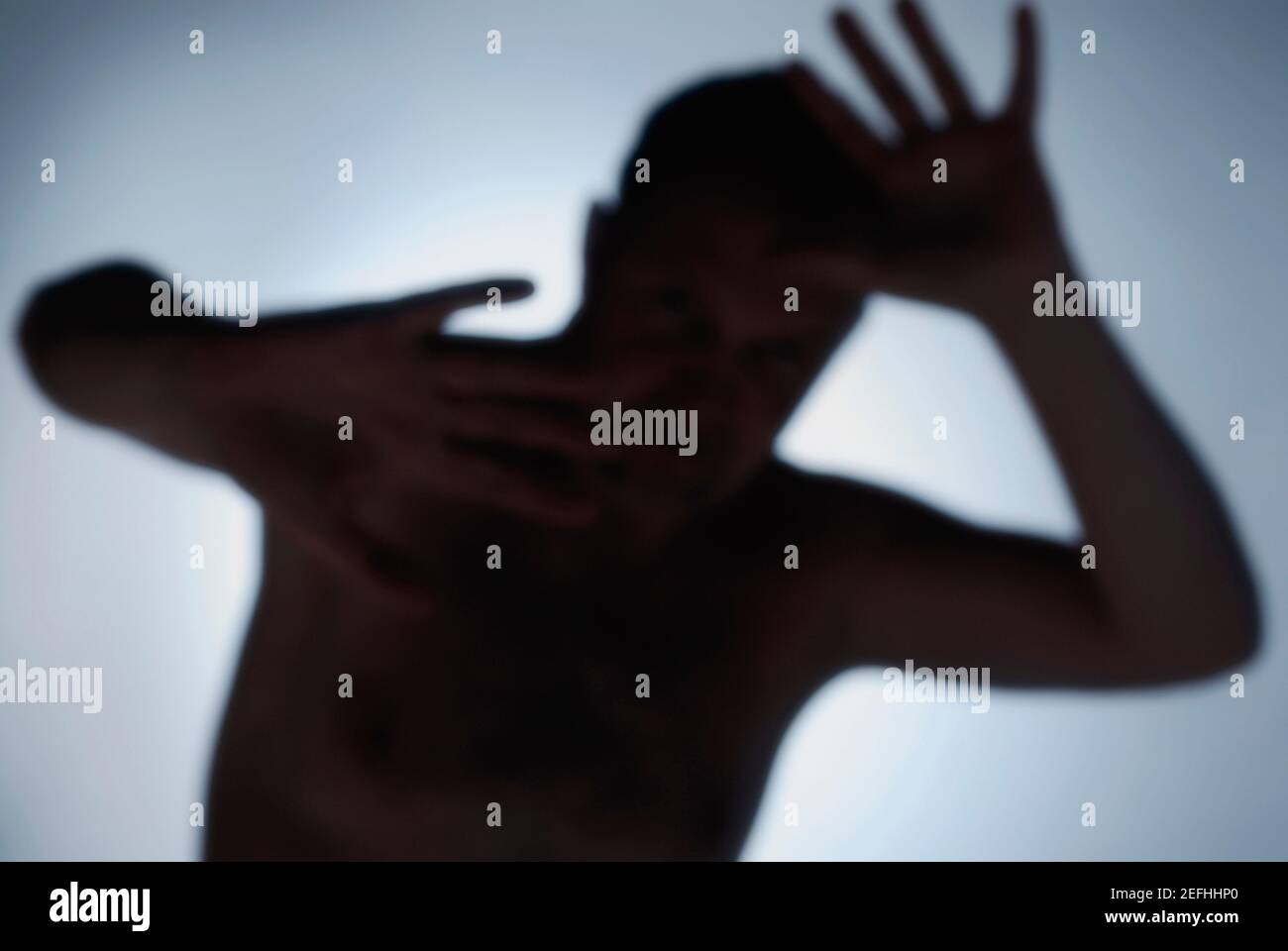 Silhouette of a man shielding his face with his arms Stock Photo - Alamy