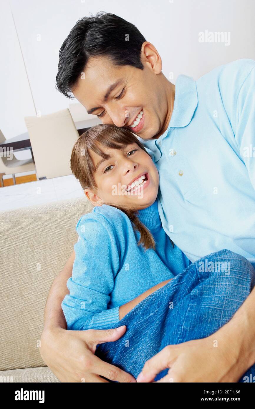 Mid adult man hugging his daughter Stock Photo - Alamy