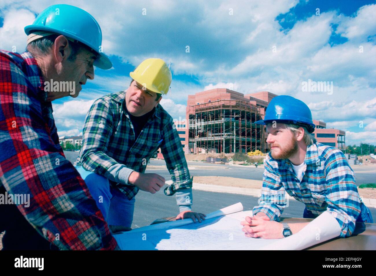 Construction crew looking at blueprints Stock Photo - Alamy