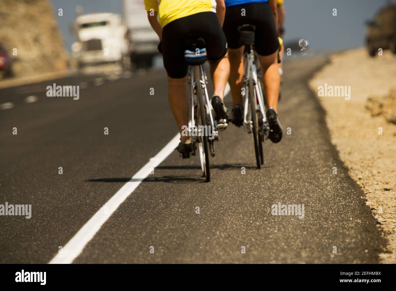 Low section view of two people riding cycles on a road Stock Photo - Alamy