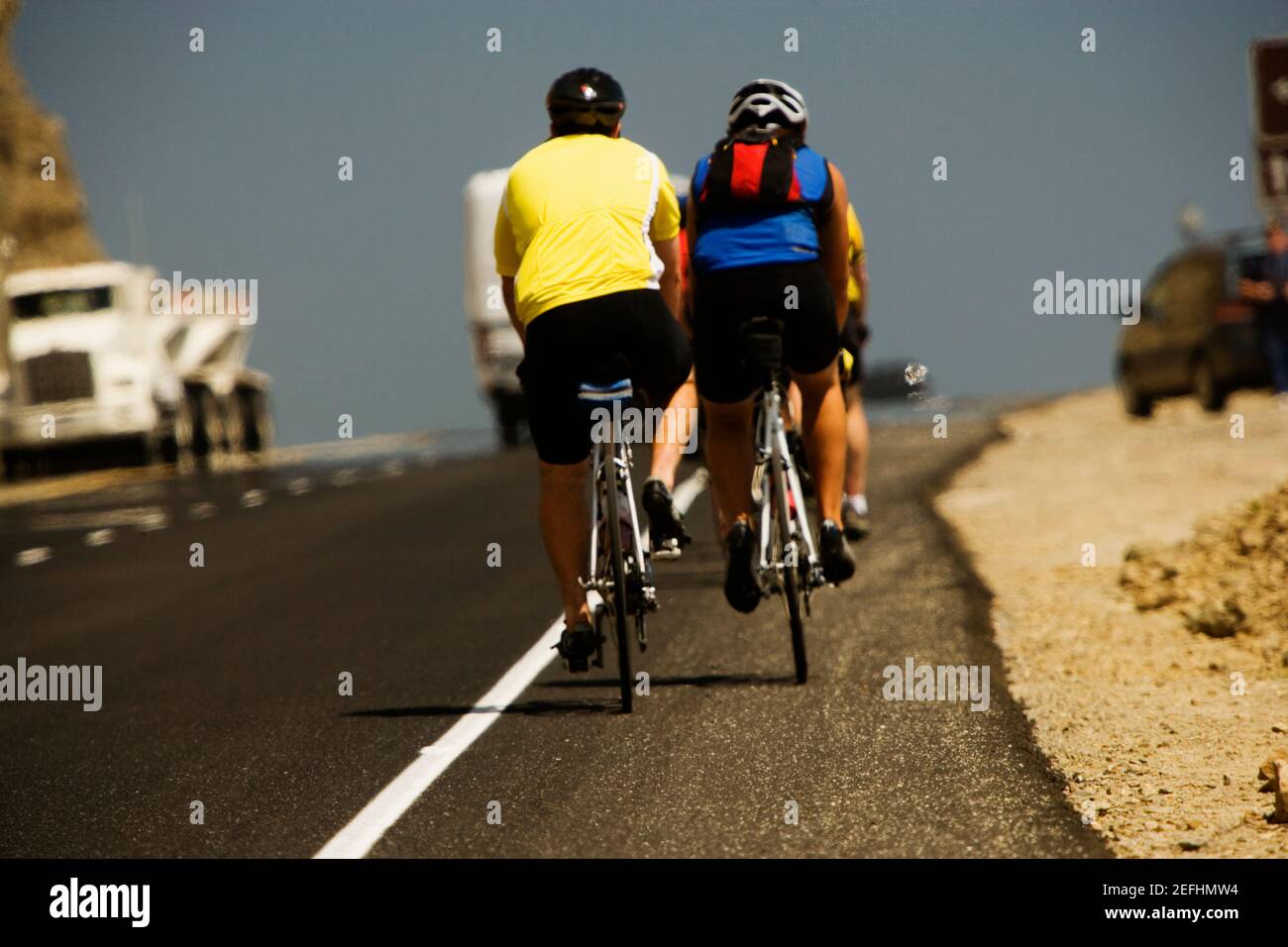 Rear view of two people riding cycles on a road Stock Photo - Alamy