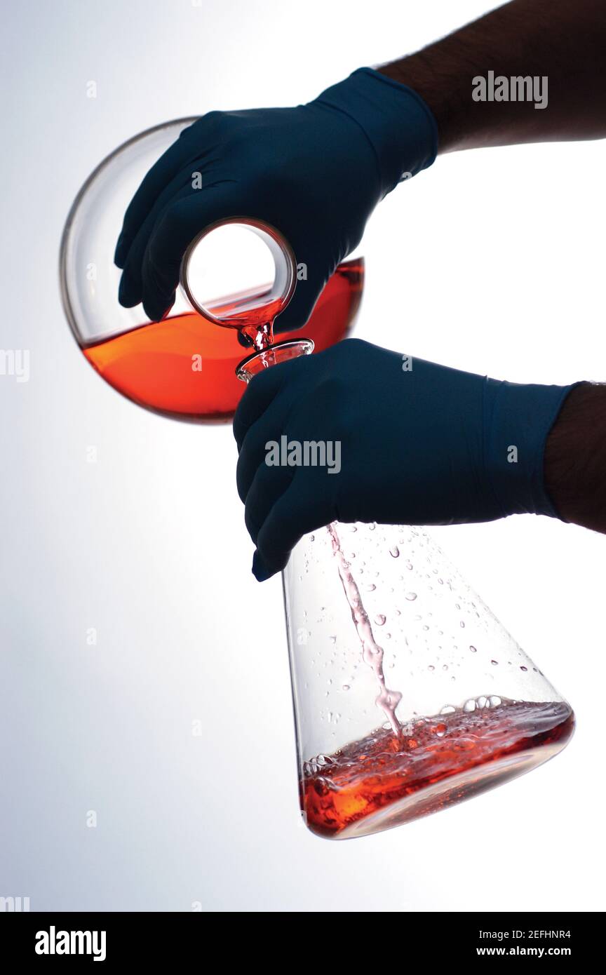Scientist pouring liquid into beaker hi-res stock photography and ...