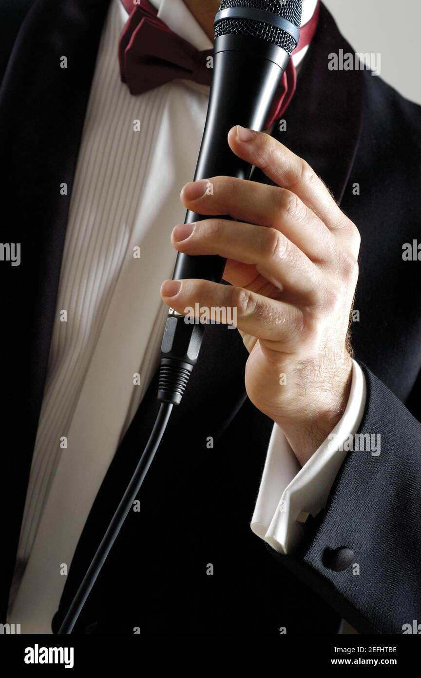 Mid section view of a singer holding a microphone Stock Photo - Alamy